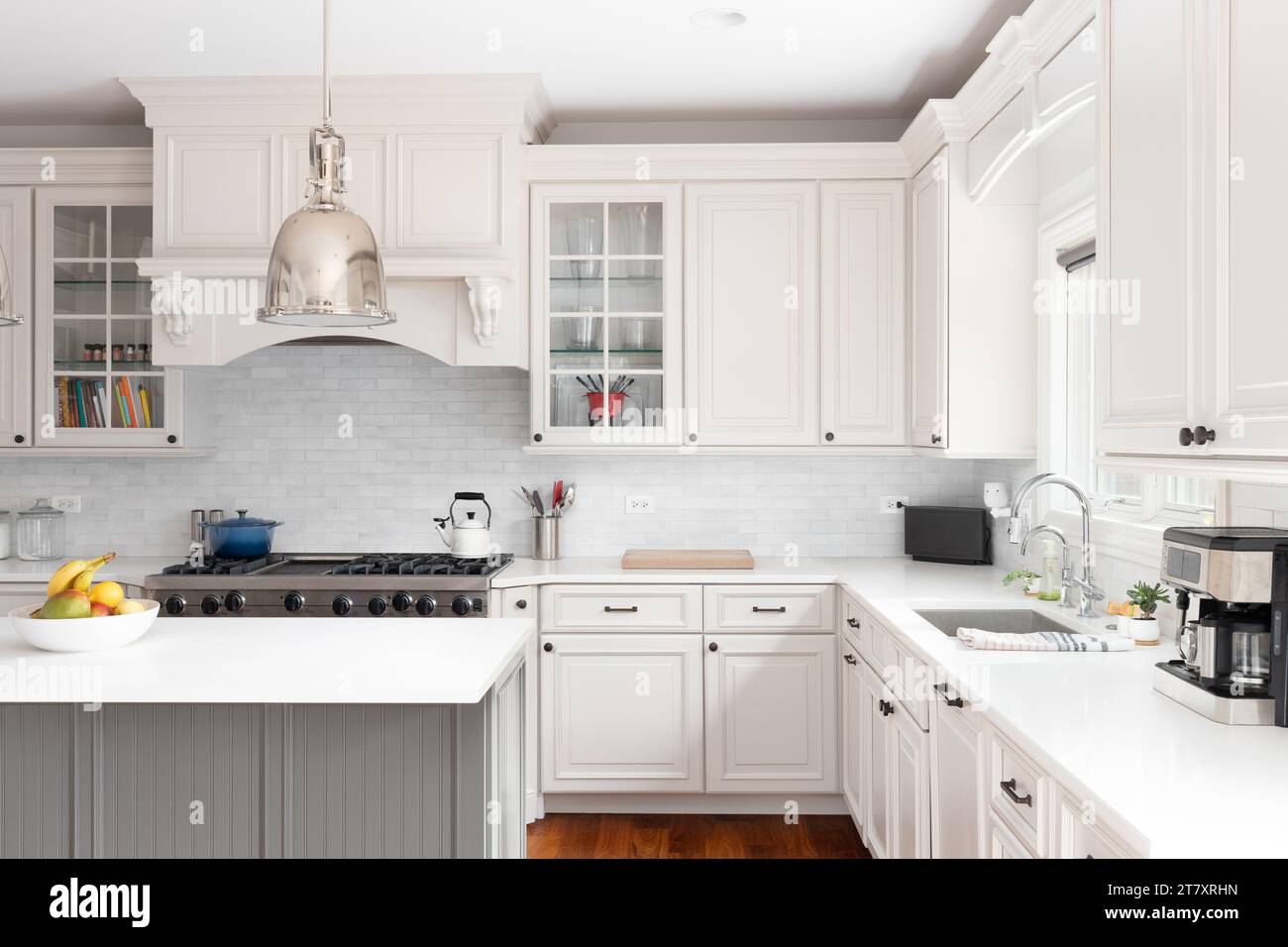 A kitchen detail with cream cabinets, a marble subway tile backsplash ...