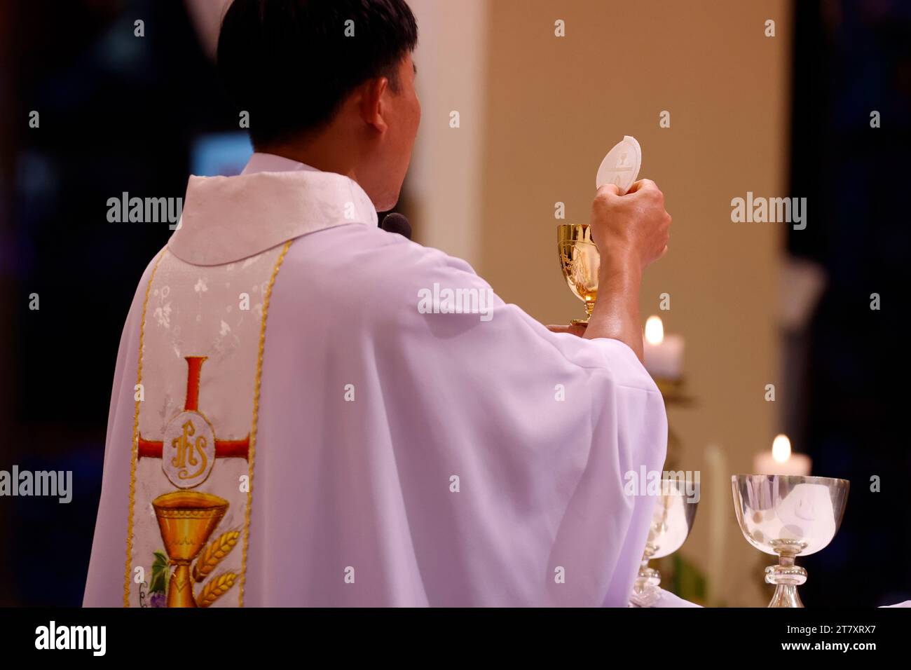 Back view of Priest with chasuble at Eucharist celebration, Sunday Mass ...
