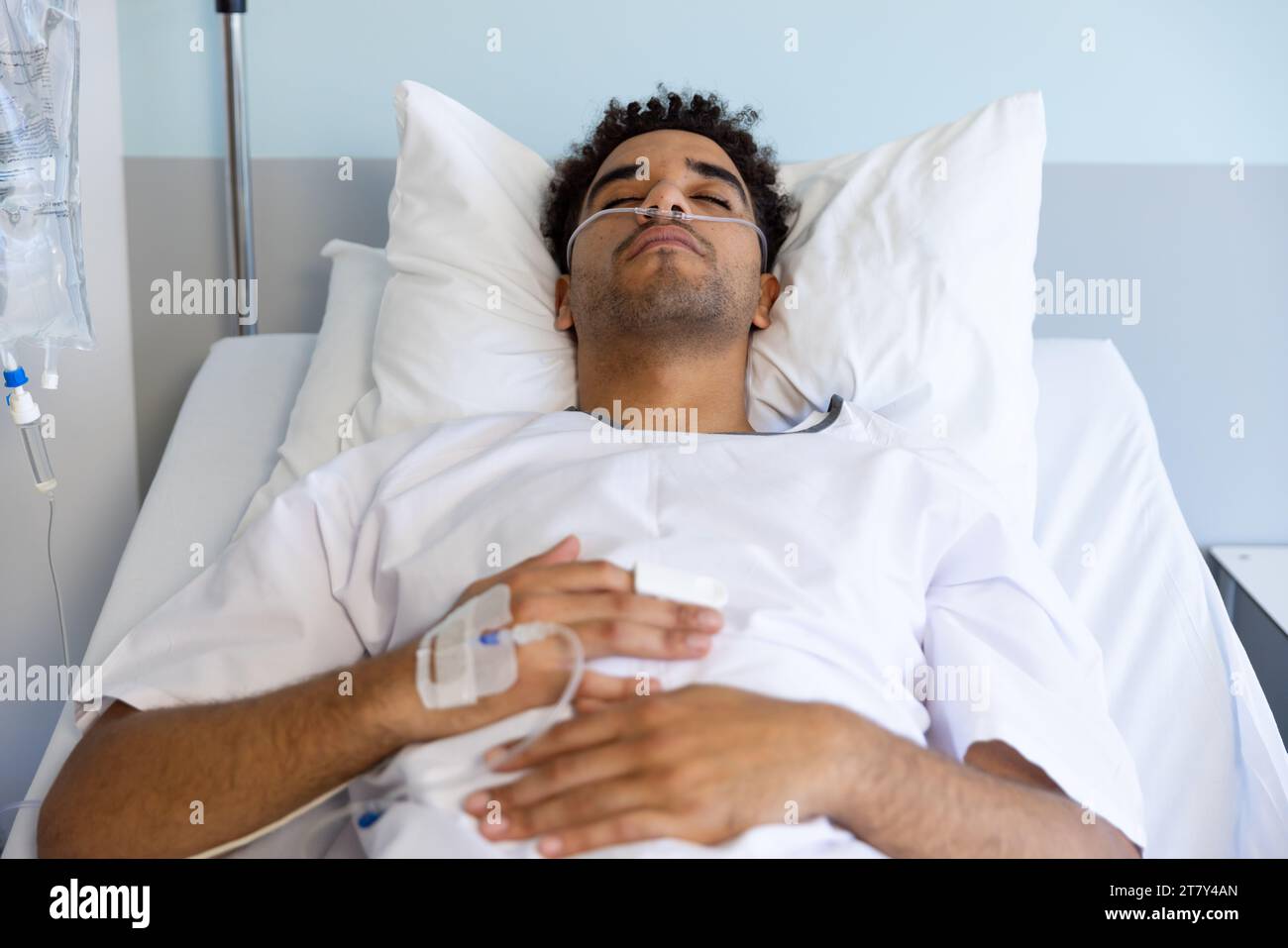 Biracial male patient sleeping in bed in sunny hospital room Stock ...