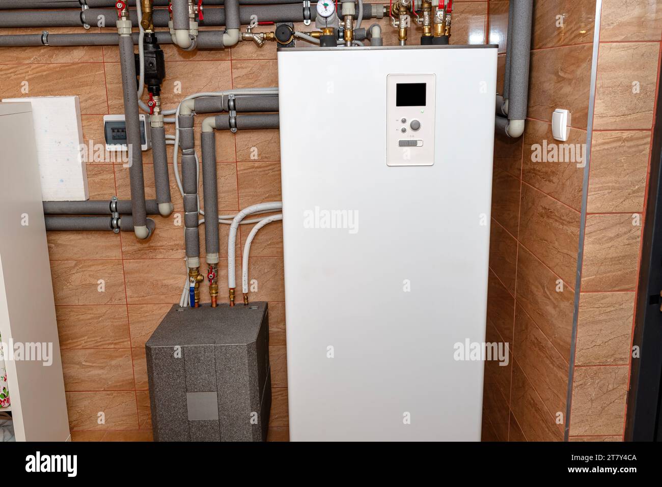 A modern air heat pump installed in the home's boiler room, visible ...