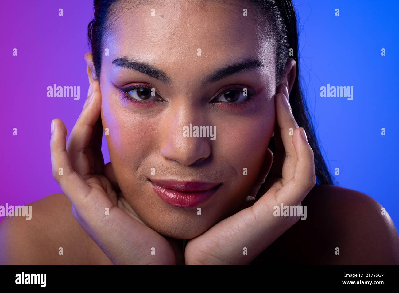 Biracial woman with dark hair, hands to face, red lips, eyeshadow make ...