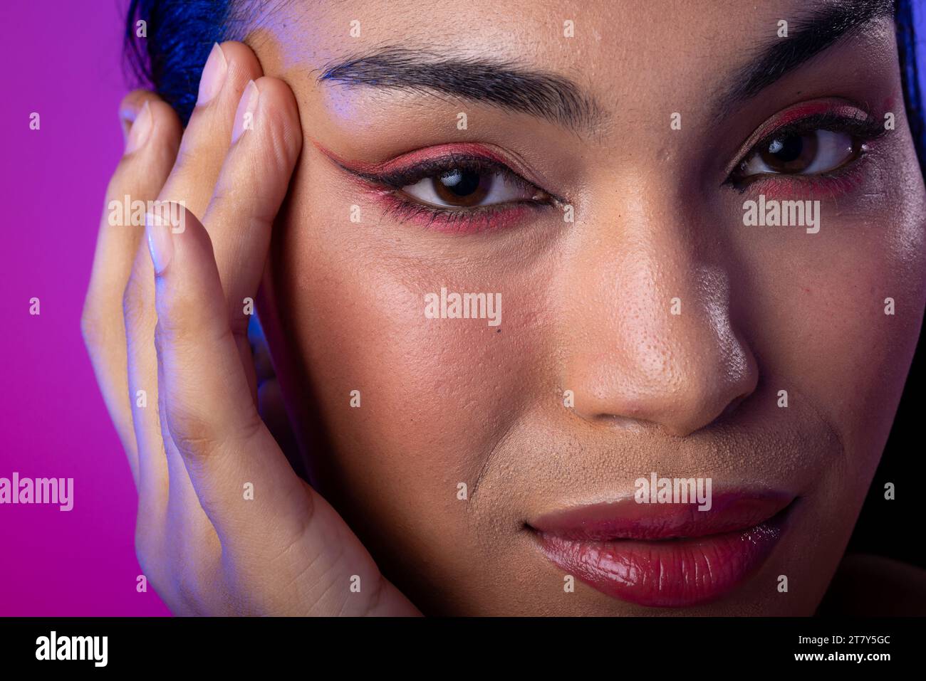 Biracial woman with dark hair, hands to face, red lips , eyeshadow make ...