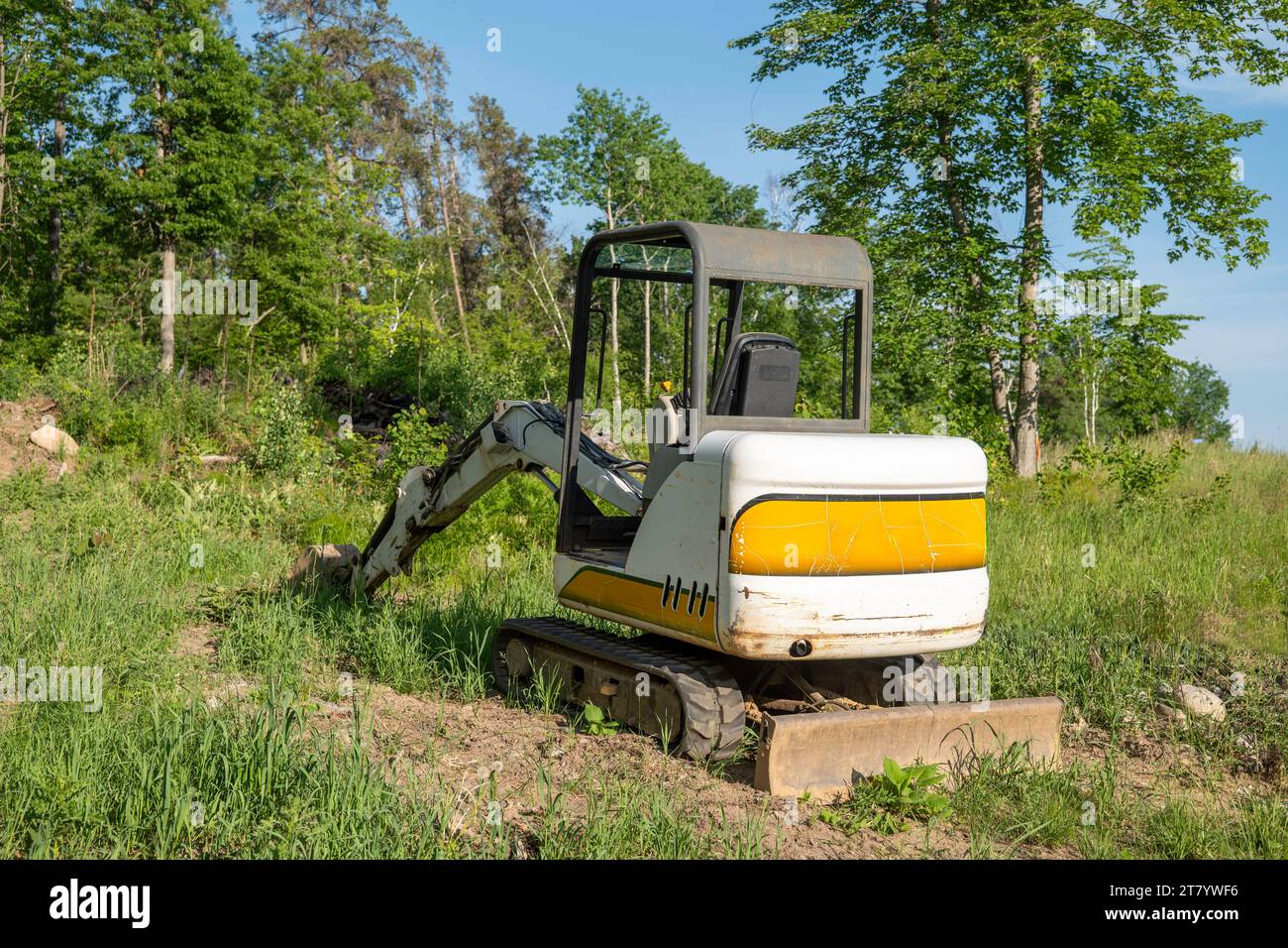 Mini excavator machine with extended arm, at a new home construction ...