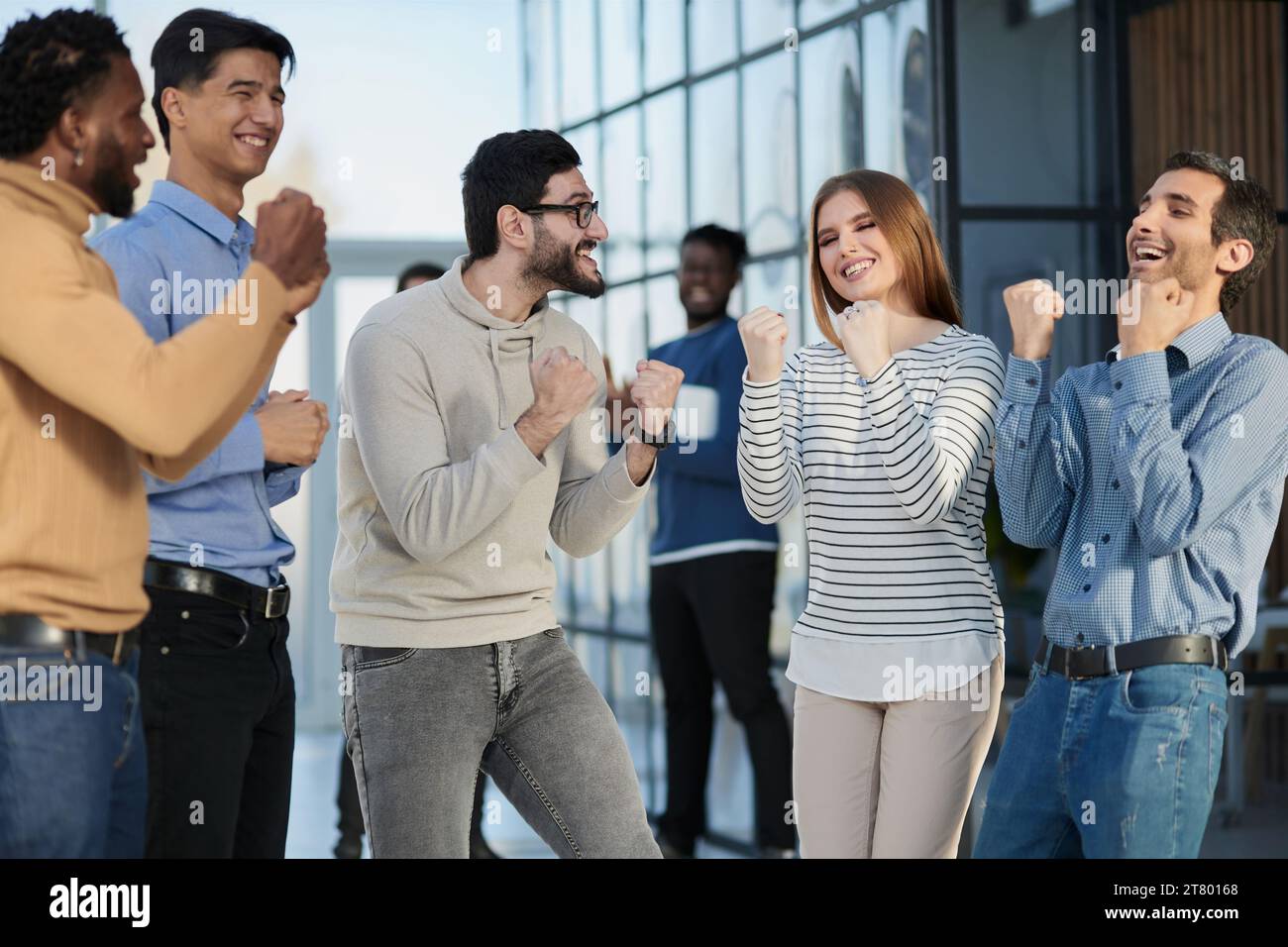 Business people celebrates and clench their fists in the air as a ...