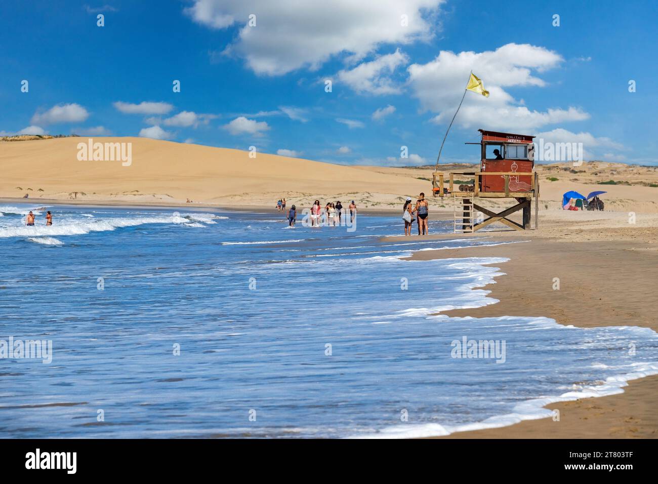 Lifeguard tower and tourists walking on the beach at Barra de Valizas ...