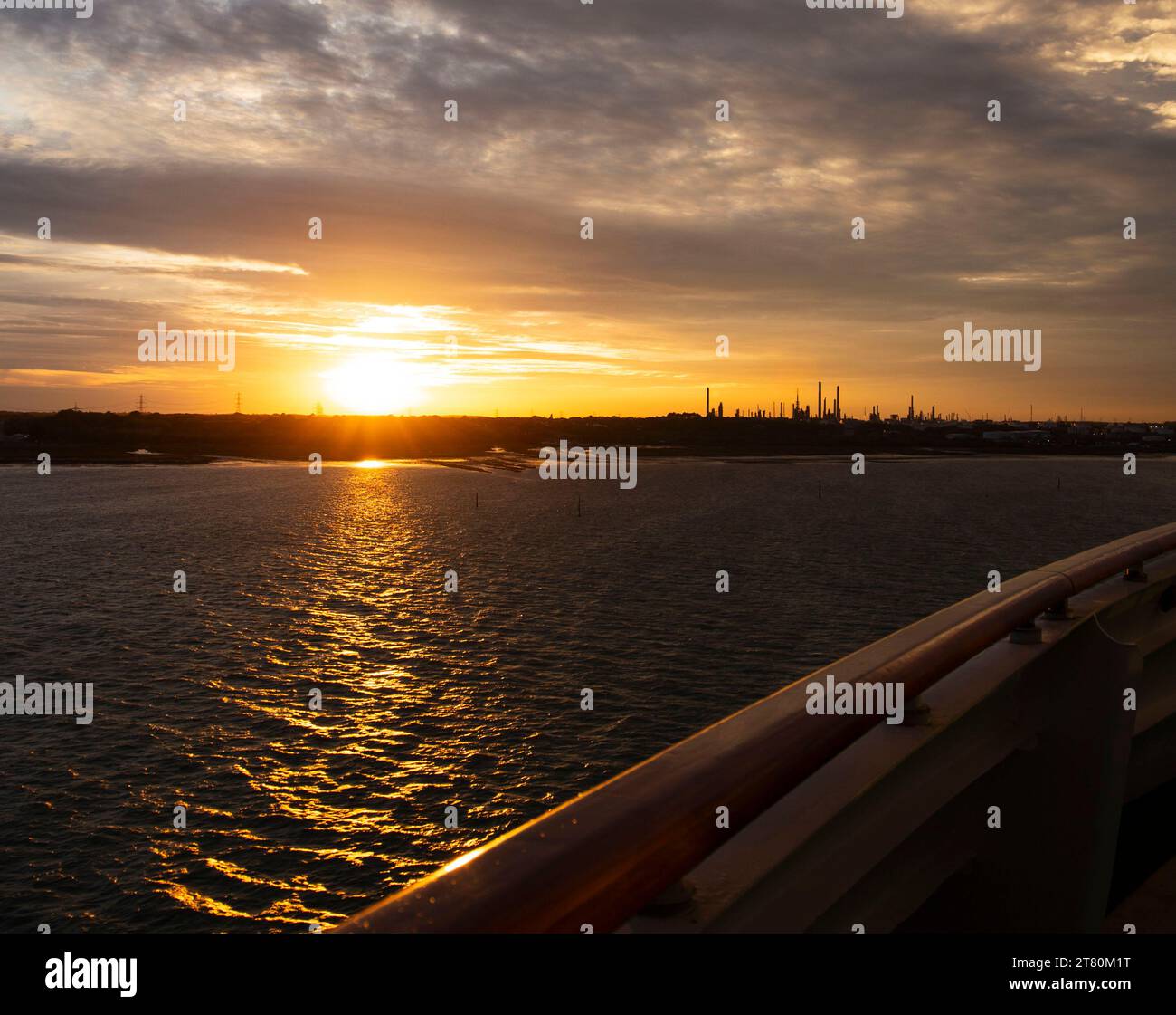 Beautiful sunset view over a calm ocean from a ship's deck railing with ...