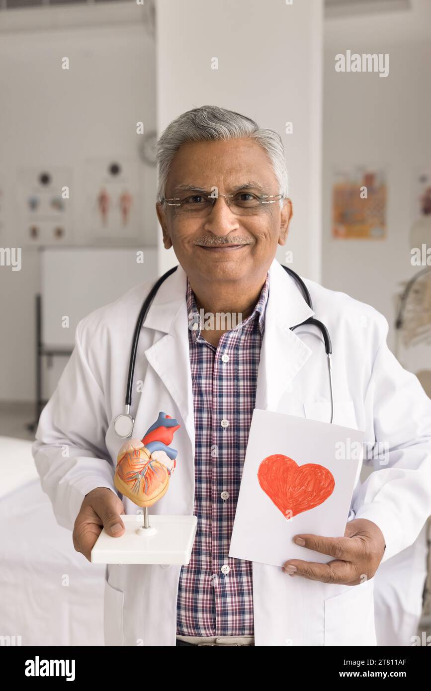 Happy elderly Indian doctor man holding human heart model Stock Photo ...