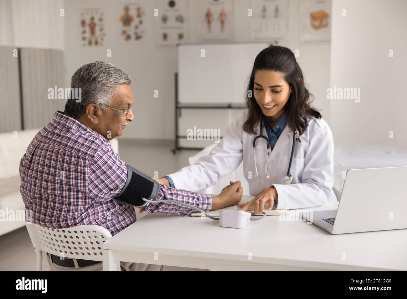 Positive young cardiologist doctor woman examining elderly geriatric patient Stock Photo - Alamy