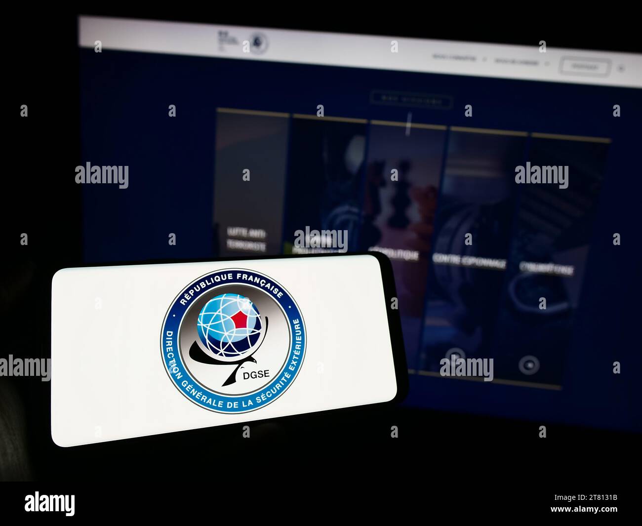 Person holding mobile phone with logo of Direction Generale de la ...