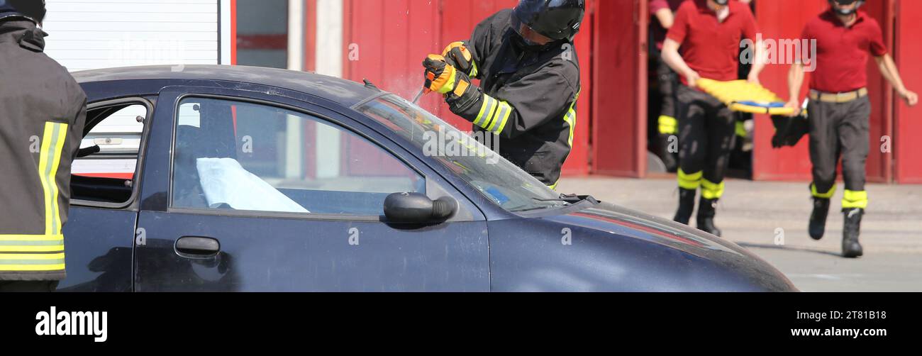 firefighter with special glass cutting hacksaw while removing the ...