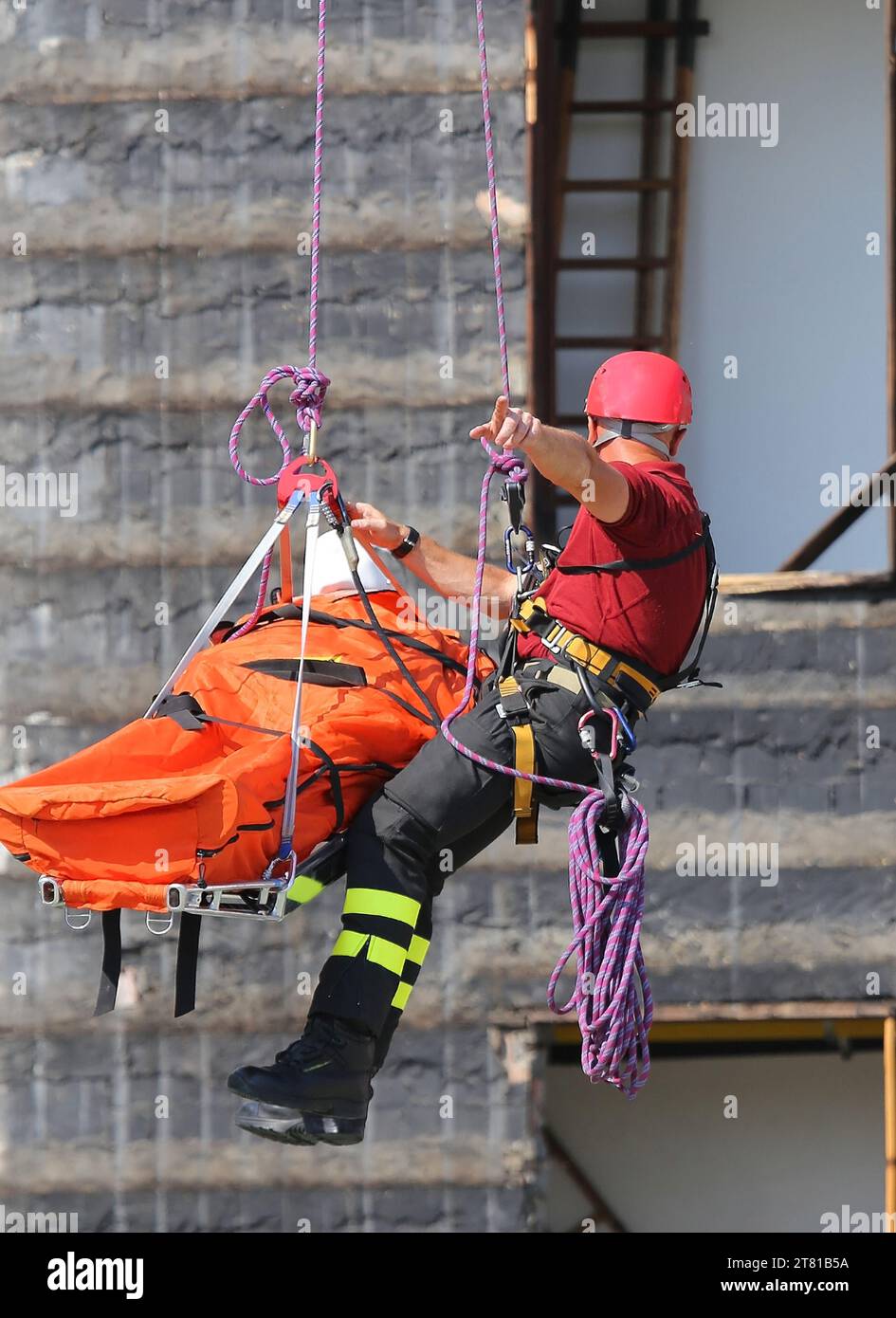 Firefighter transporting the injured person on a stretcher to rescue ...