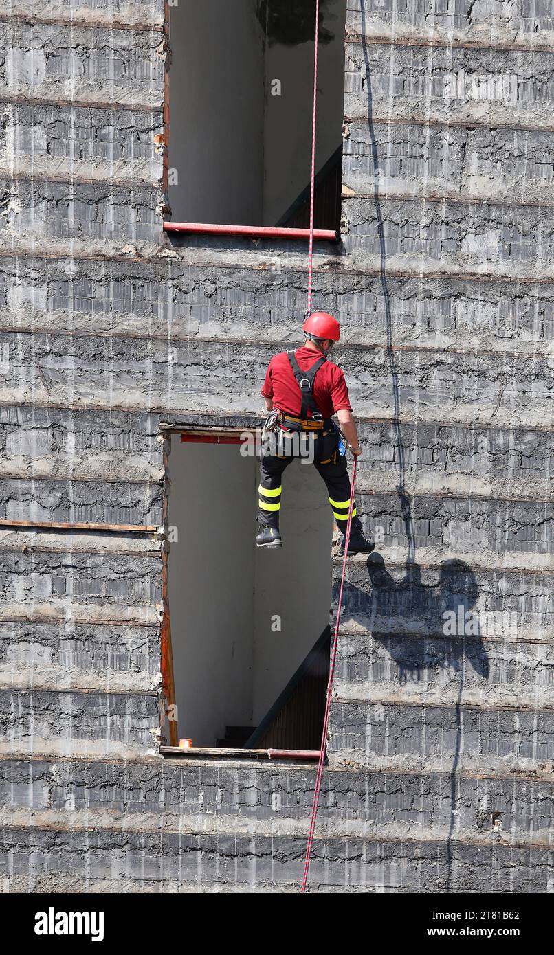 Courageous fireman in harness climbing over a destroyed building Stock ...