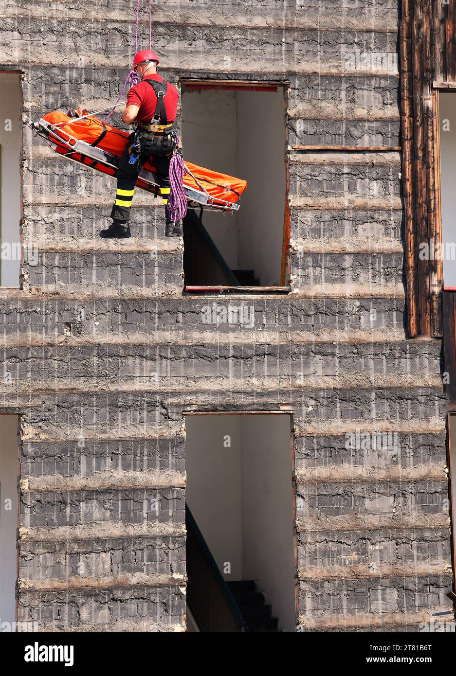 firefighter while transporting the injured person on a stretcher to ...