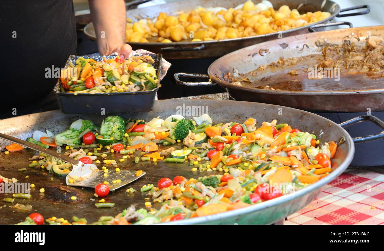pan with cooked vegetables with broccoli carrots corn peppers tomatoes ...