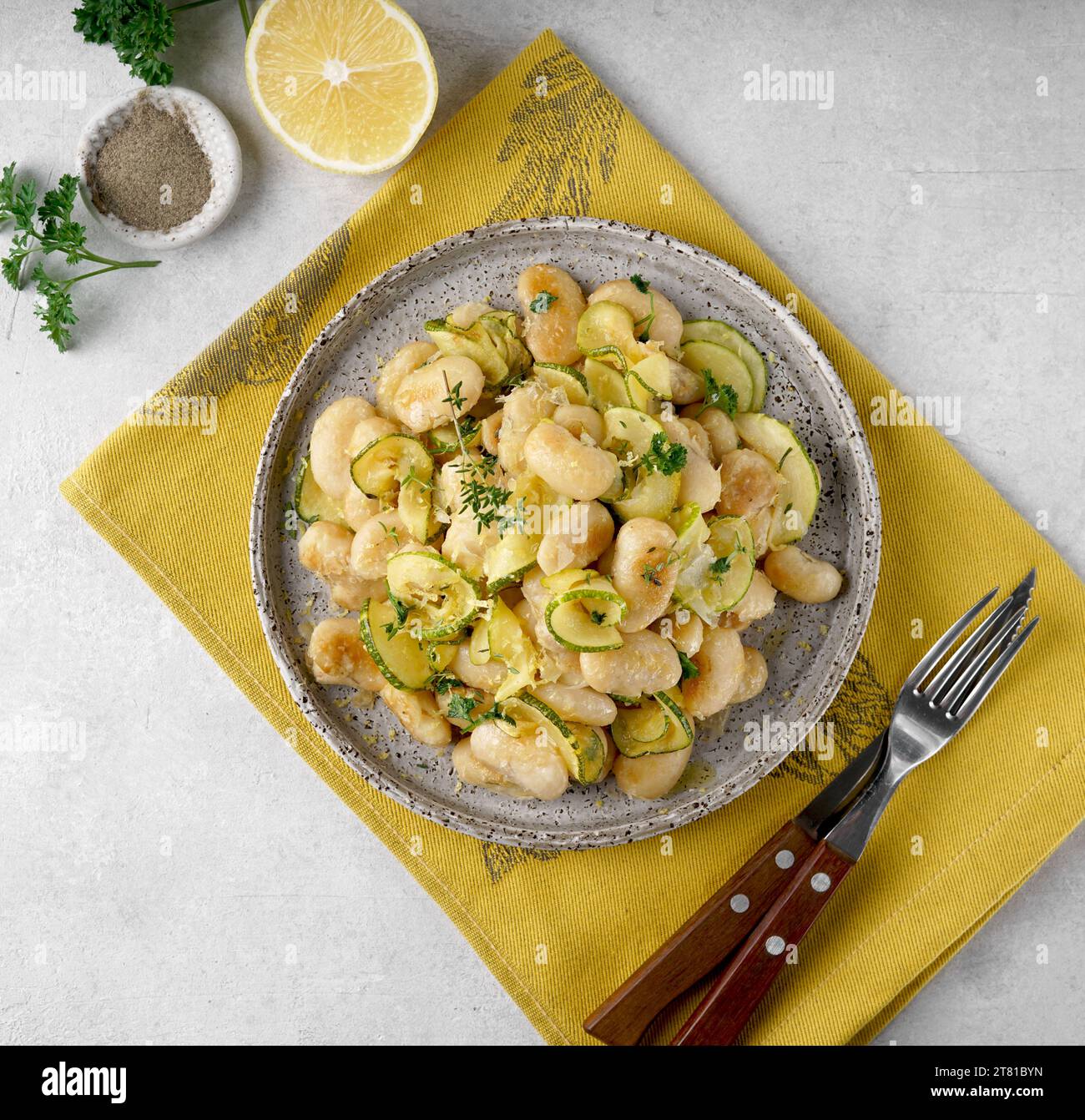 Crispy beans with zucchini and lemon n the gray plate. Cooked vegan or ...