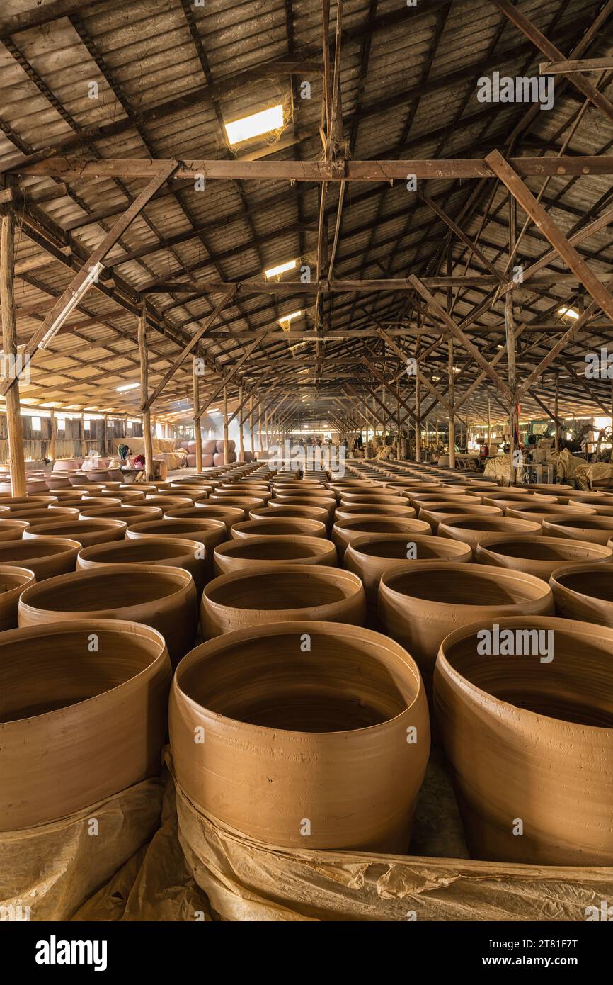 An expansive warehouse with an abundance of pottery bowls beneath a ...