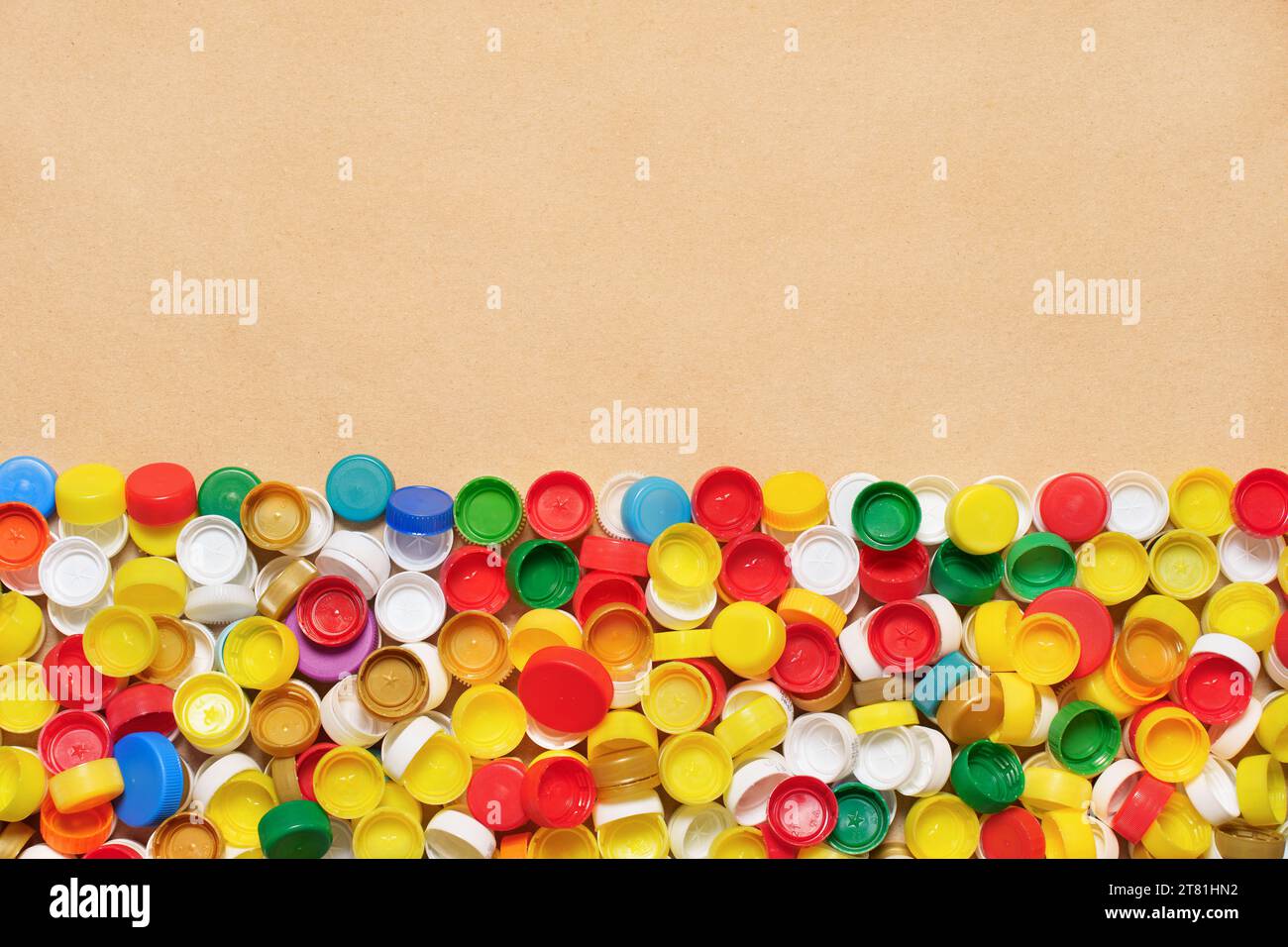 Collection of plastic caps on cardboard background. PET recycling ...
