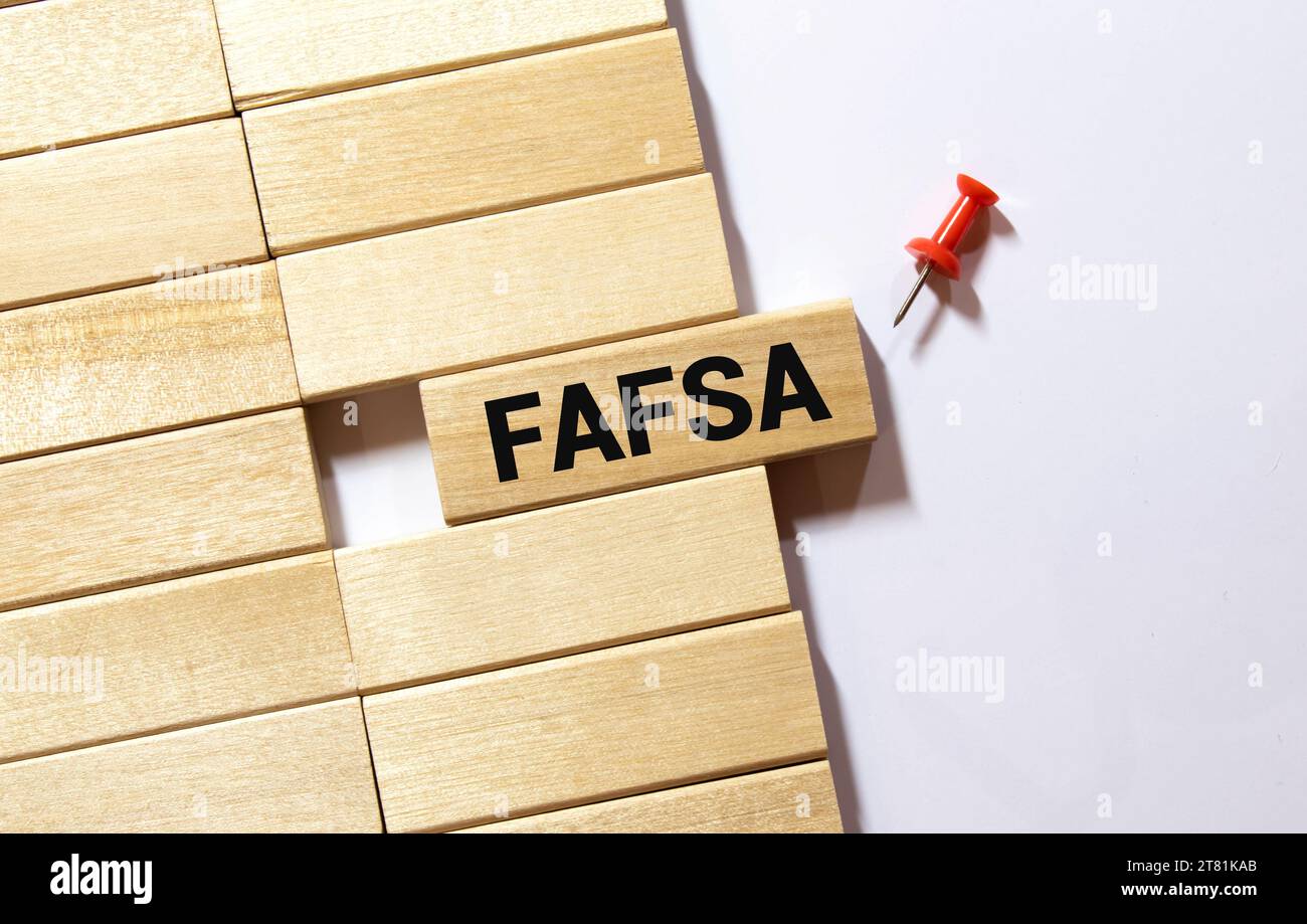 Businessman hand holding wooden cube block with FAFSA business word on ...