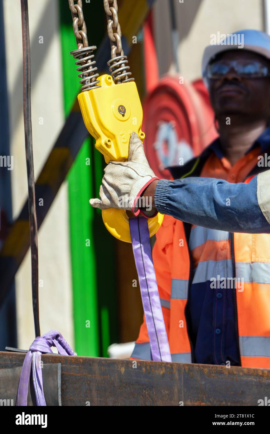 african american man holding the hook, working with a small crane on ...