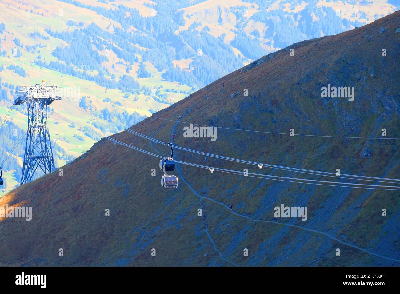 A cable car routes from Interlaken, is hanging in the sky, aiming at ...