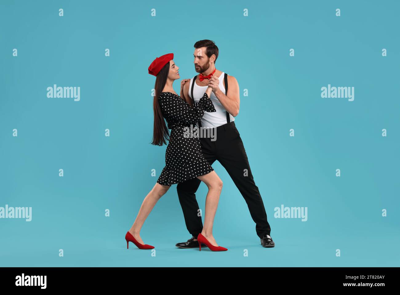 Beautiful couple dancing together on light blue background Stock Photo ...