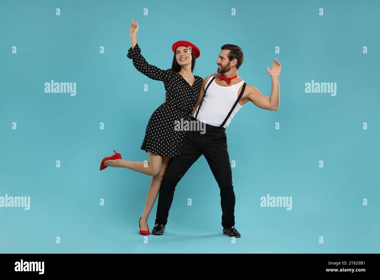 Happy couple dancing together on light blue background Stock Photo - Alamy