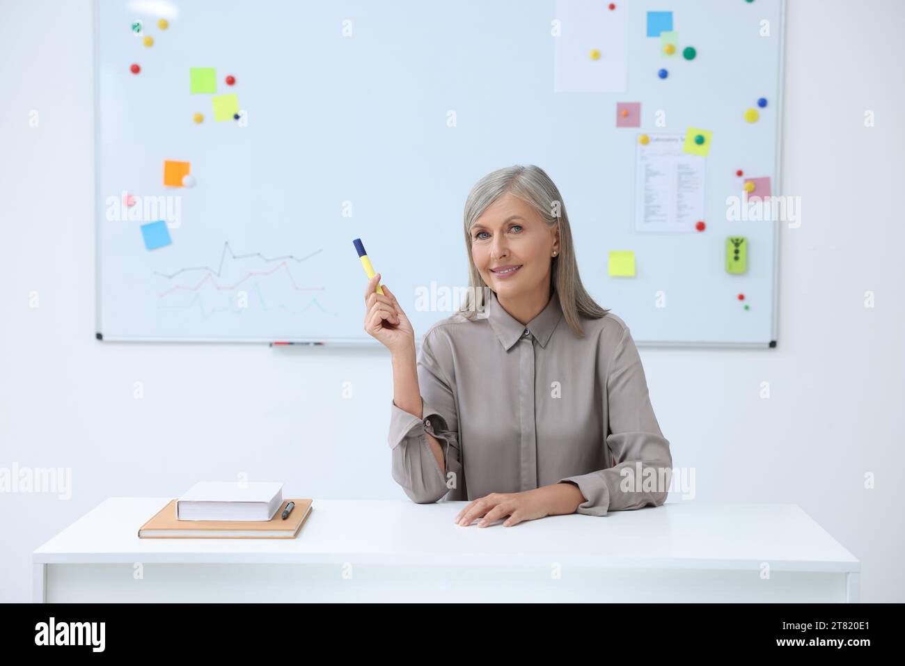 Happy professor giving lecture at desk in classroom, space for text ...