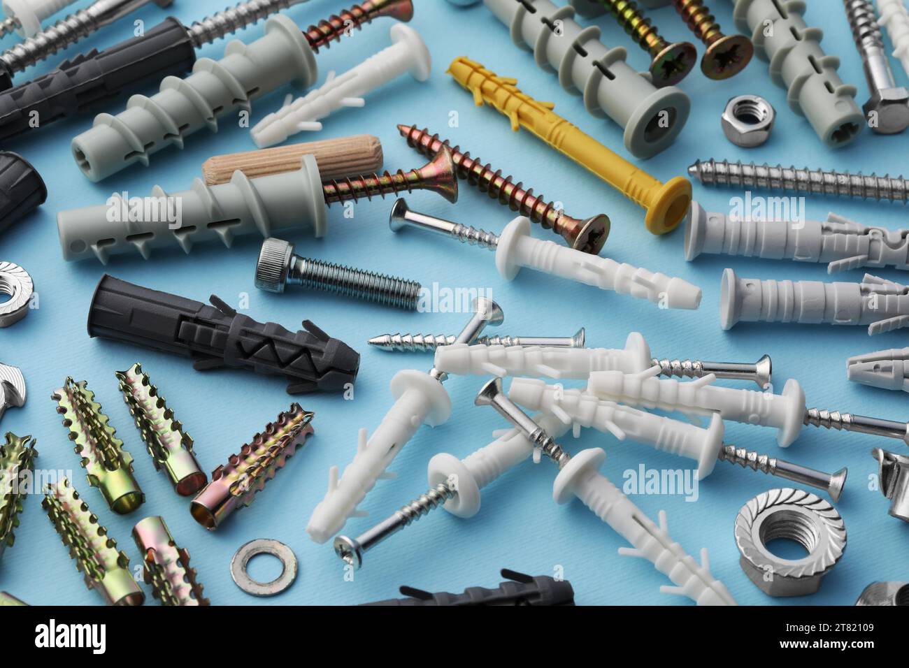 Many different fasteners and dowels on light blue background, above ...