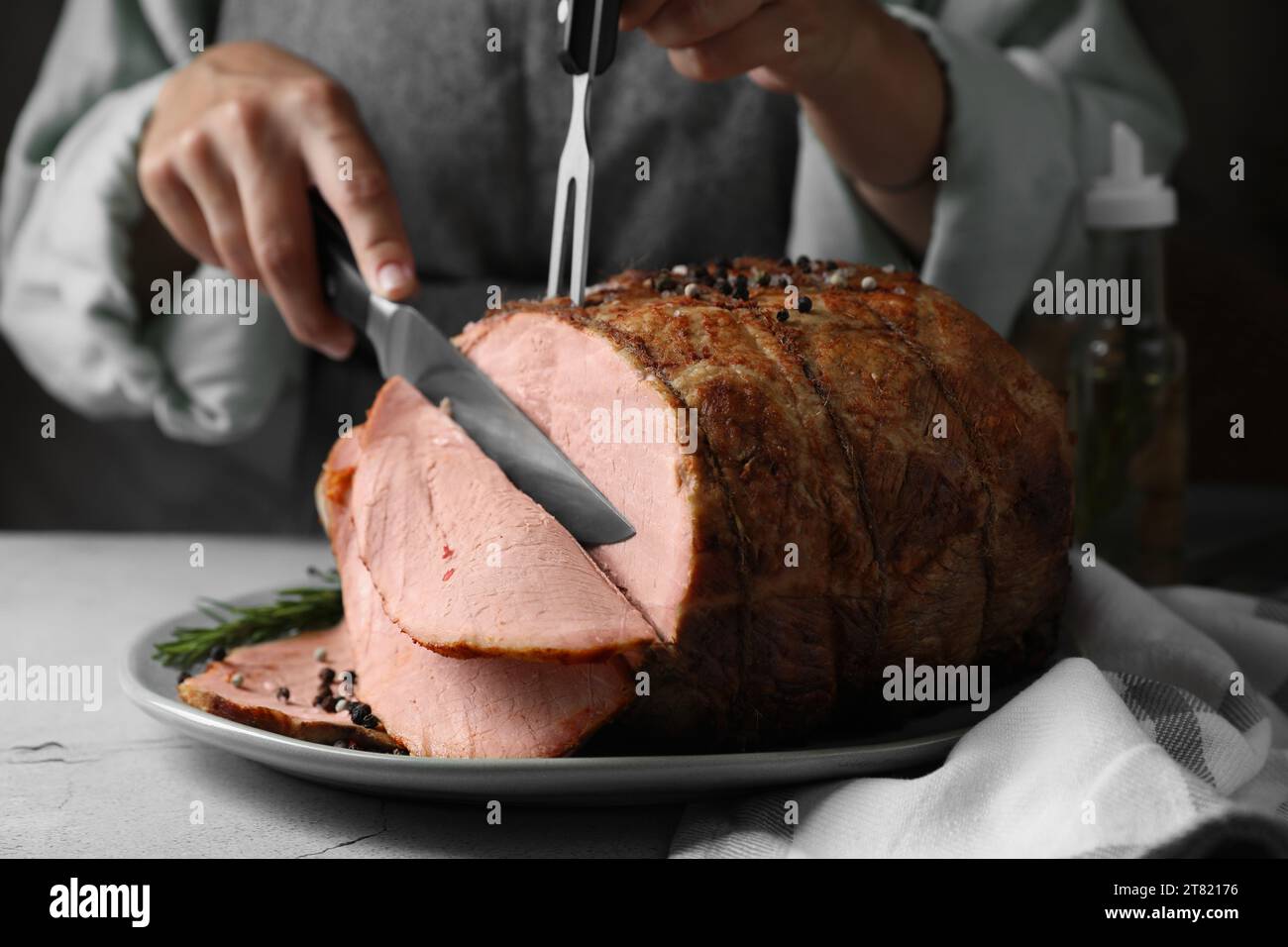Woman cutting delicious baked ham at light grey table, closeup Stock ...
