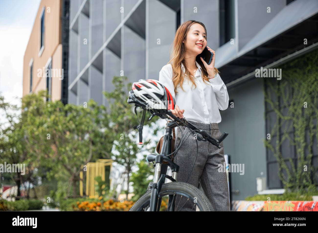 A smiling businesswoman holding her smartphone takes a break from the ...