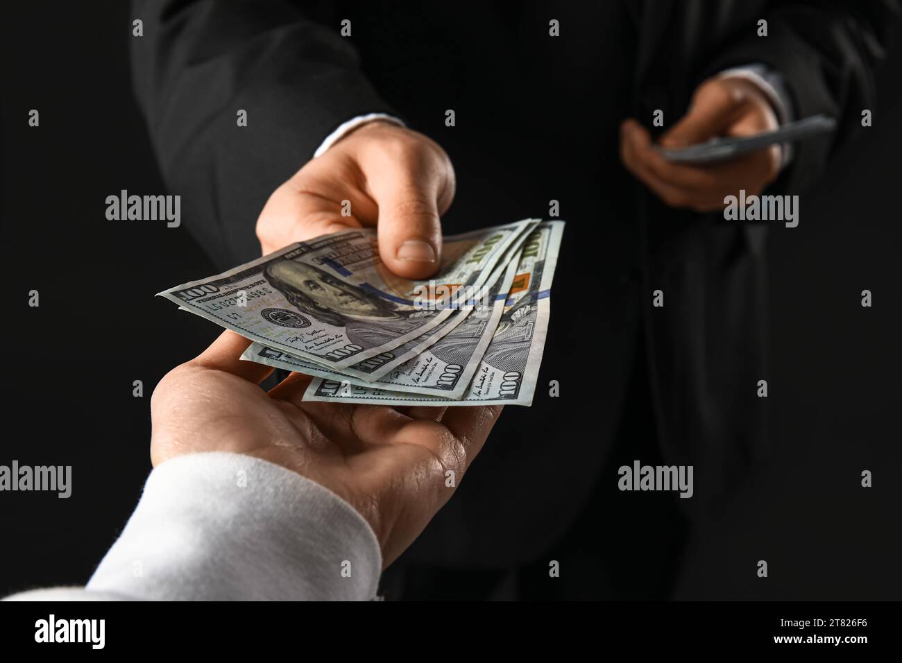 Young businessman giving bribe on dark background, closeup Stock Photo ...