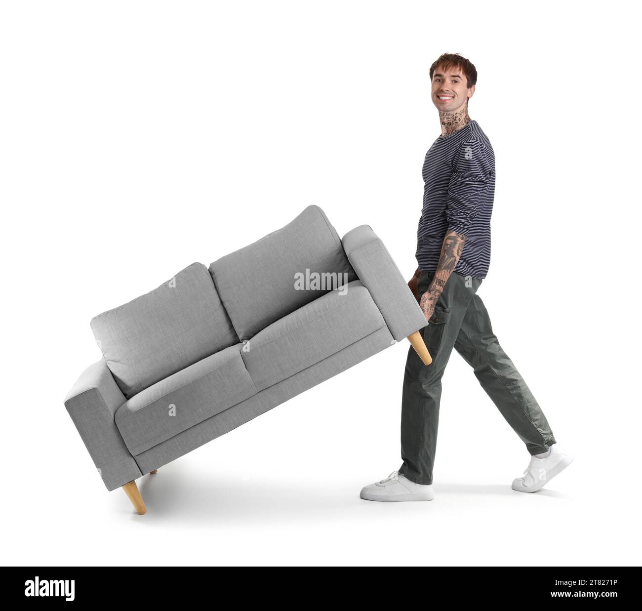 Young man carrying sofa on white background Stock Photo - Alamy