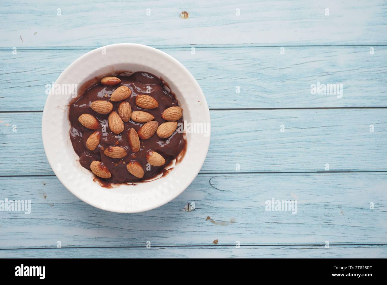 dark chocolate cream pouring on almond nut on white Stock Photo - Alamy
