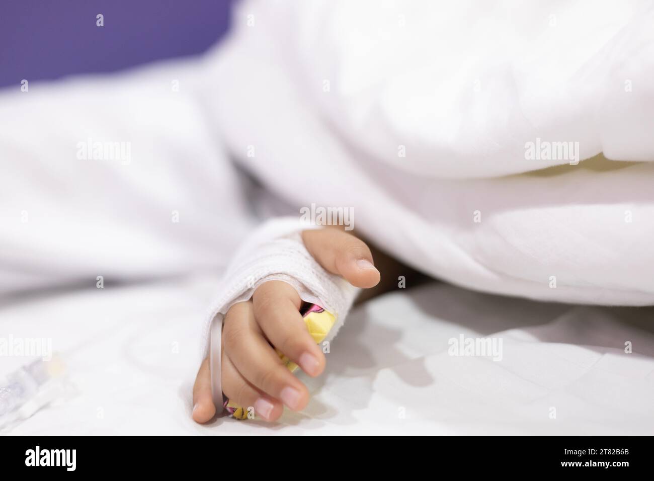 Child's hand fever patients have IV tube in hospital. Toddler girl ...