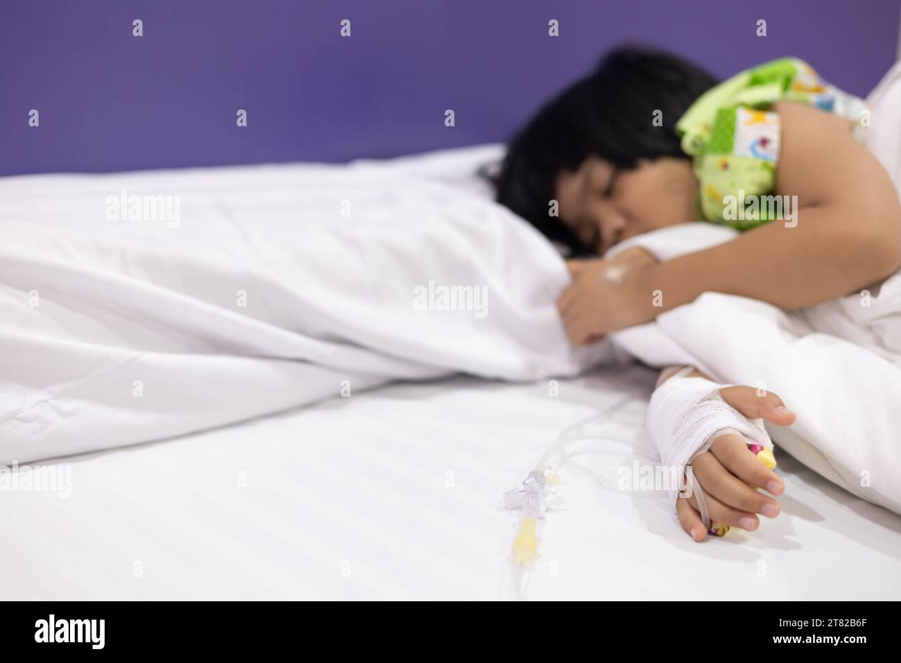Child's hand fever patients have IV tube in hospital. Toddler girl ...
