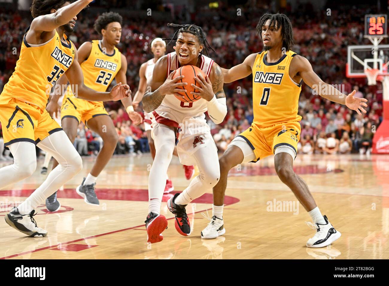 Arkansas guard Khalif Battle, center, tries to get past UNC Greensboro ...