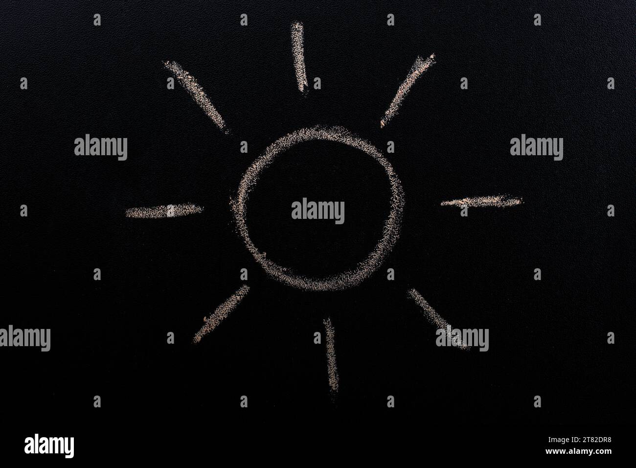 Hand drew sun by chalk with light ray shape on blackboard background ...