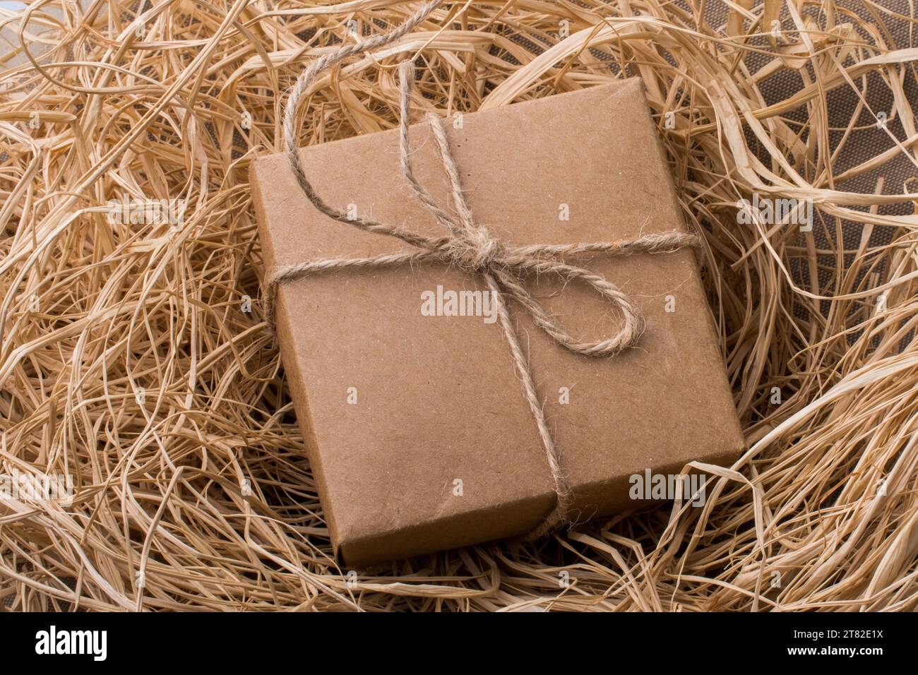 Gift box of brown color on a straw filled background Stock Photo - Alamy