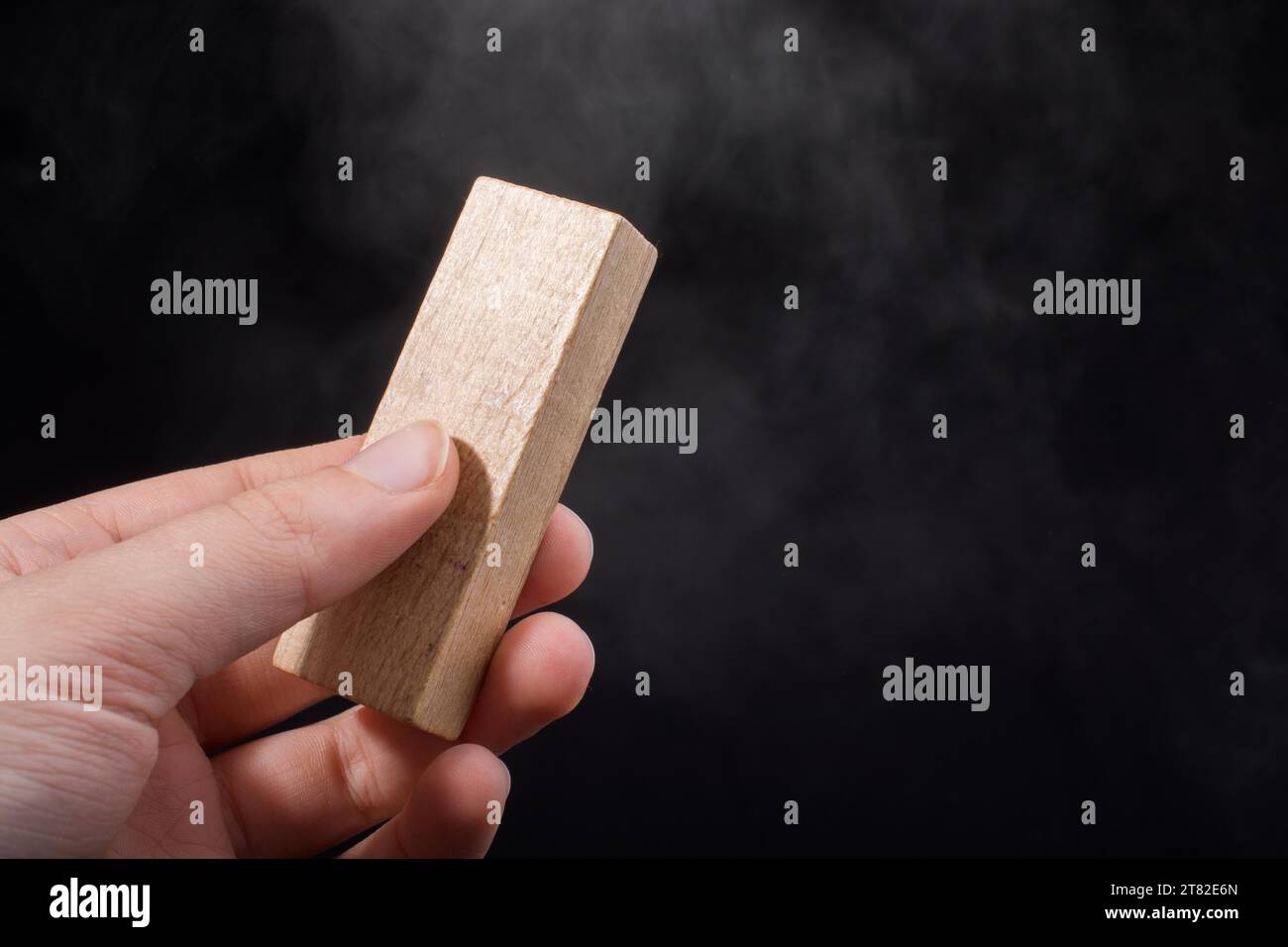 Small piece of cut wood in hand background Stock Photo - Alamy