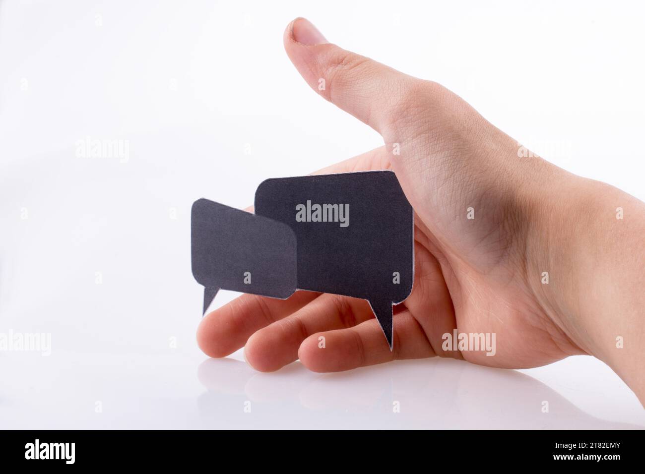 Hand holding dialogue boxes on a white background Stock Photo - Alamy