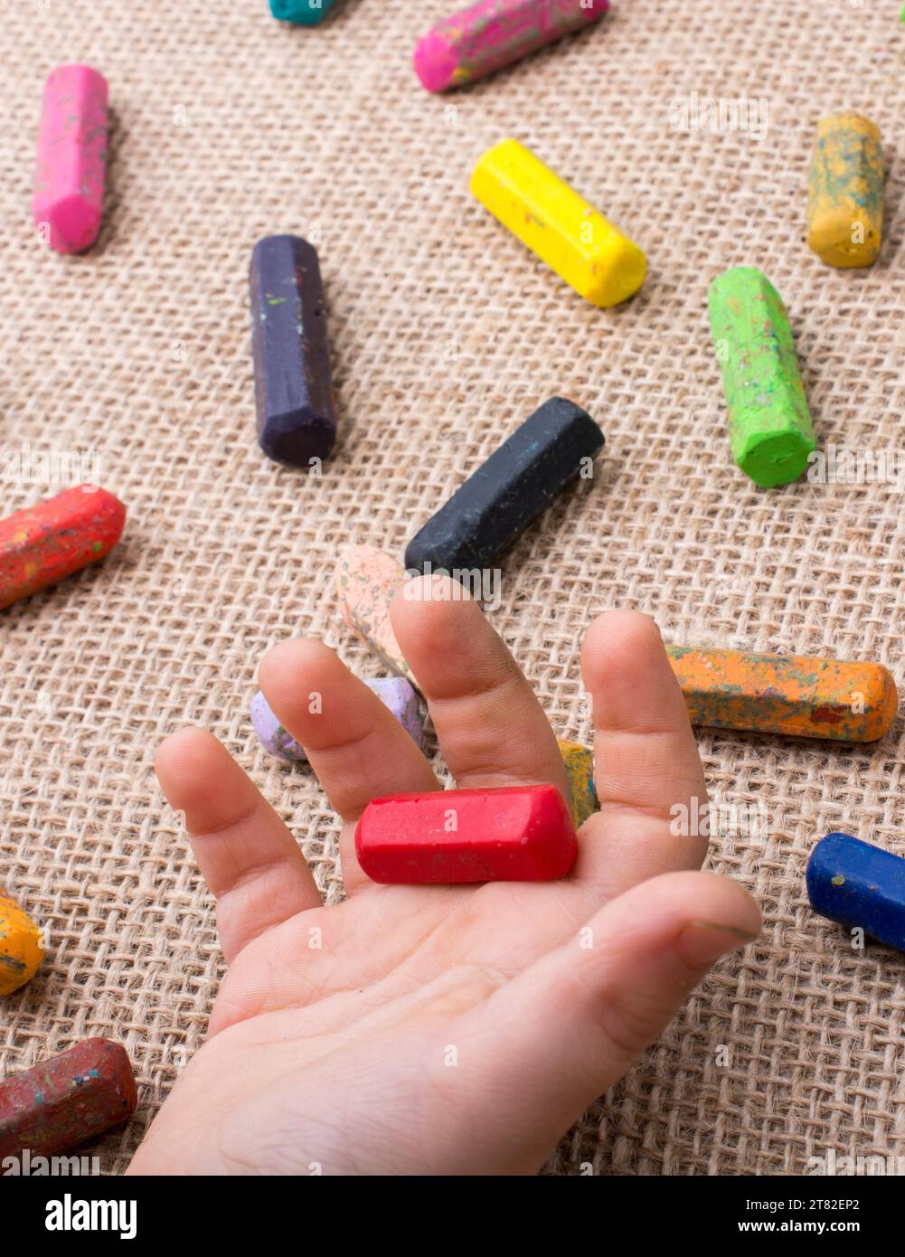 Used color crayons and a toddlers hand holding one Stock Photo - Alamy