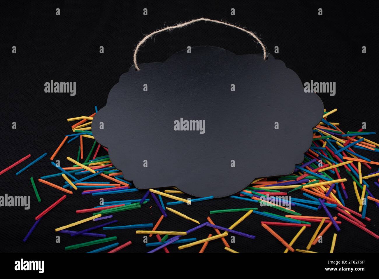 Black speech bubble shaped notice board on colorful sticks on black ...