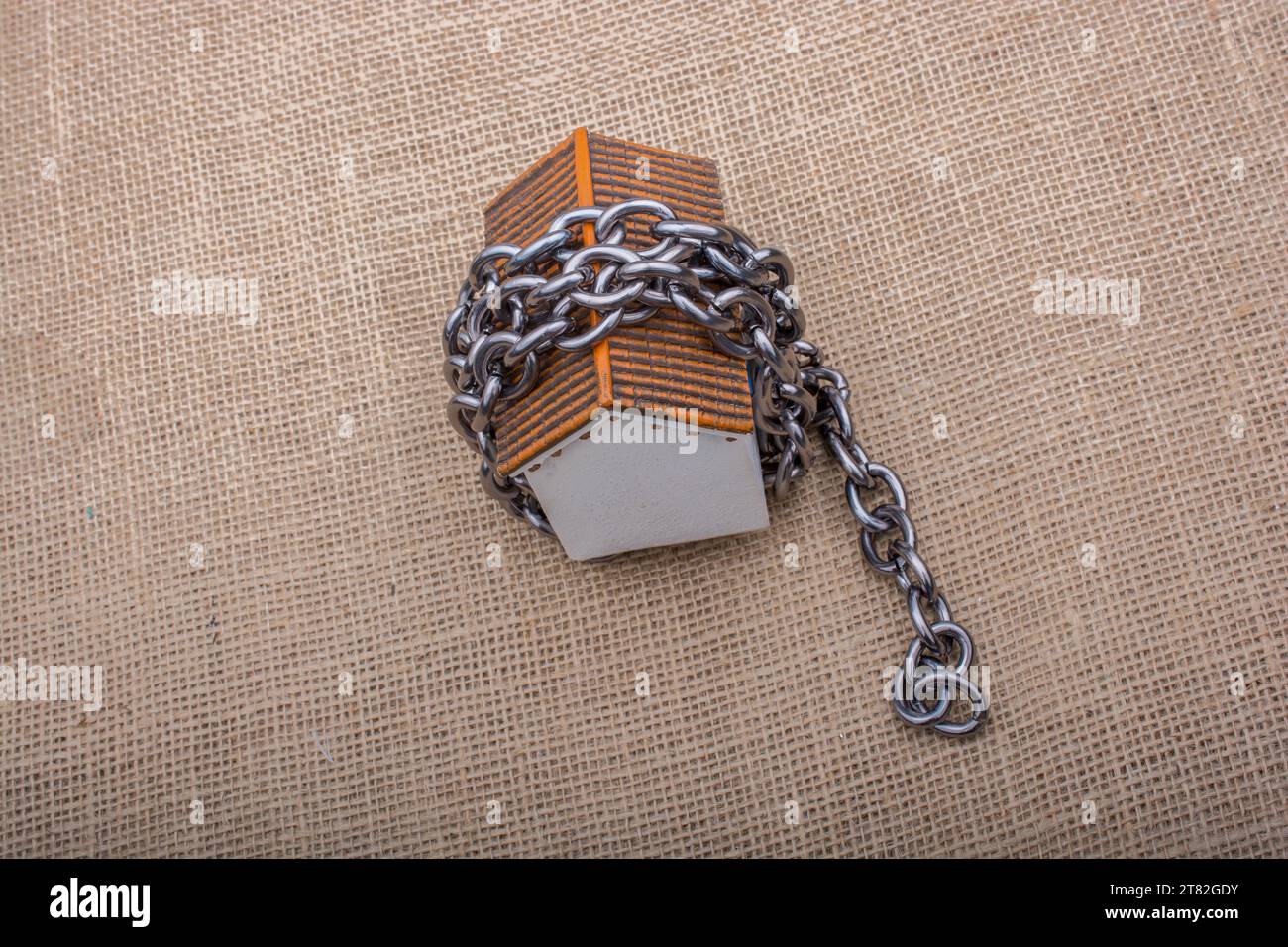 Chain wrapped around a model house on a brown background Stock Photo ...