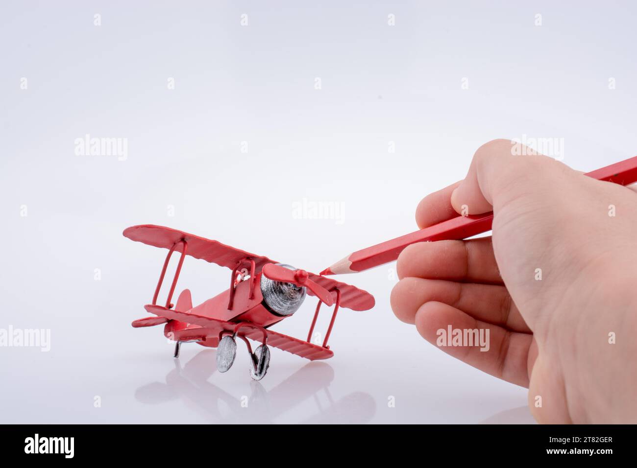 Red color pen in touch with little metal model airplane Stock Photo - Alamy