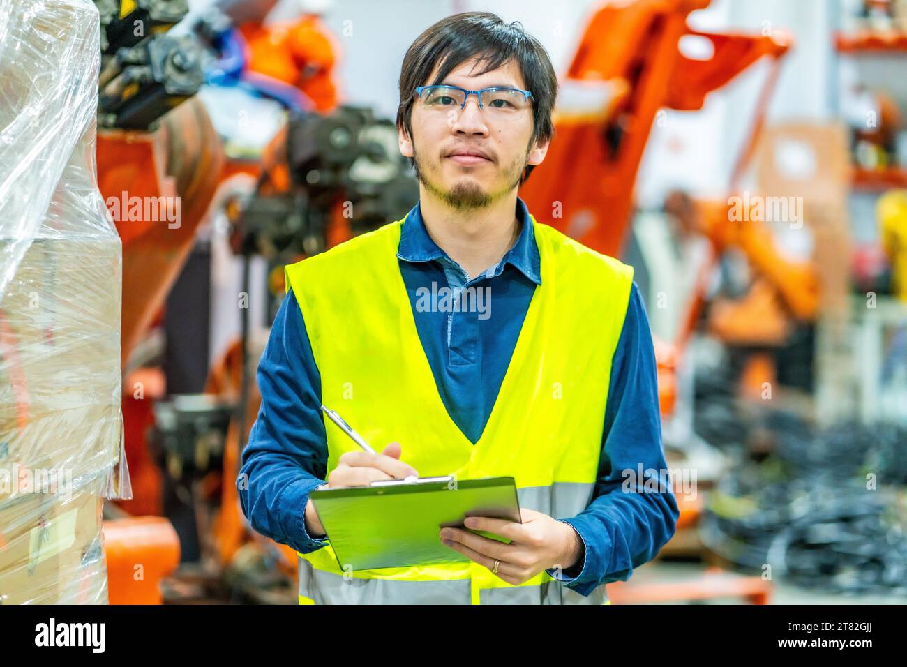 Japanese engineer preparing production reports in an assembly line of ...