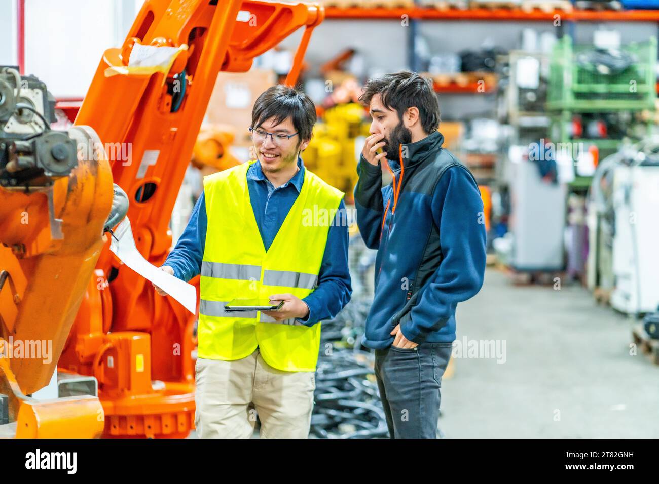 Software engineer explaining to controlling robotic welding process to ...