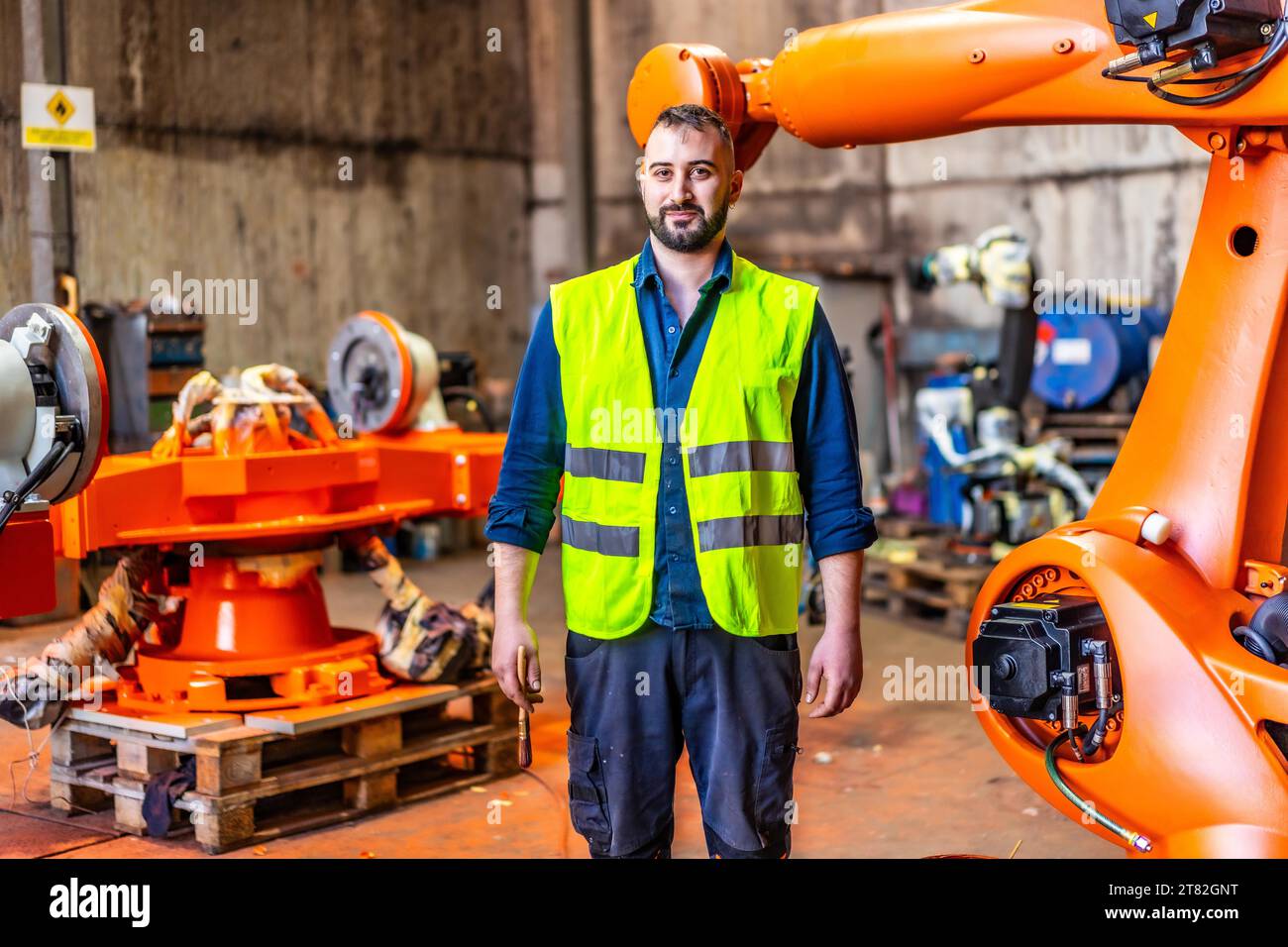 Portrait of a mechanic in uniform in an industry that build robotic ...