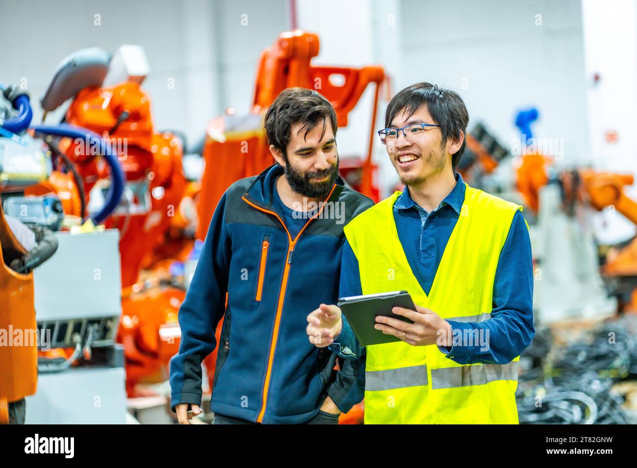 Multicultural team of engineers controlling the production of robotic ...