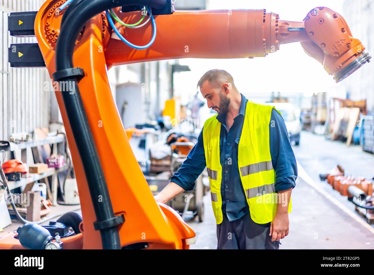 Young worker uses a paintbrush to paint an industrial robotic arm Stock ...