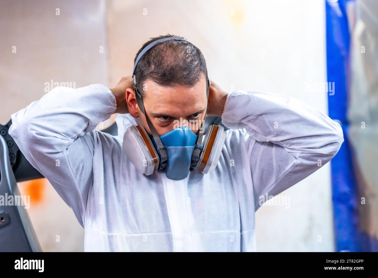 Close-up photo of an industrial painter putting on protective gear for ...